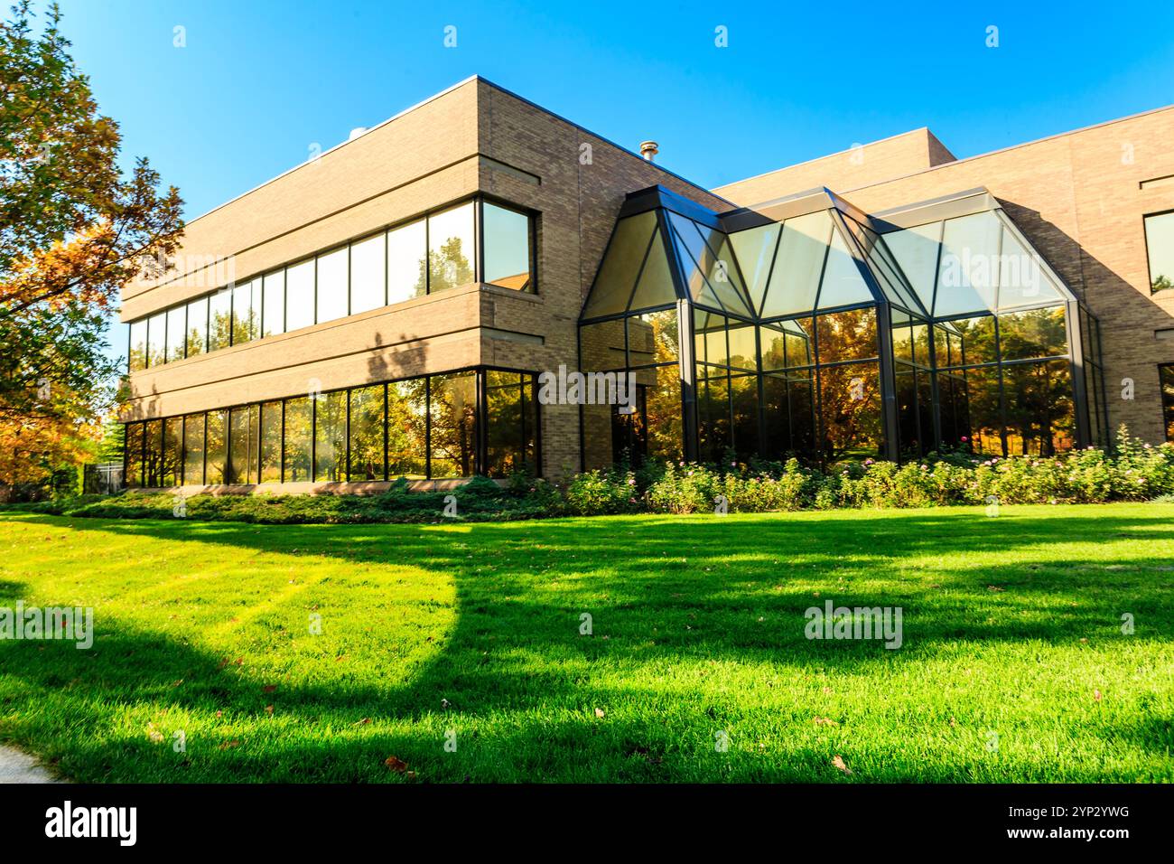 A large building with a green lawn in front of it. The building has a ...