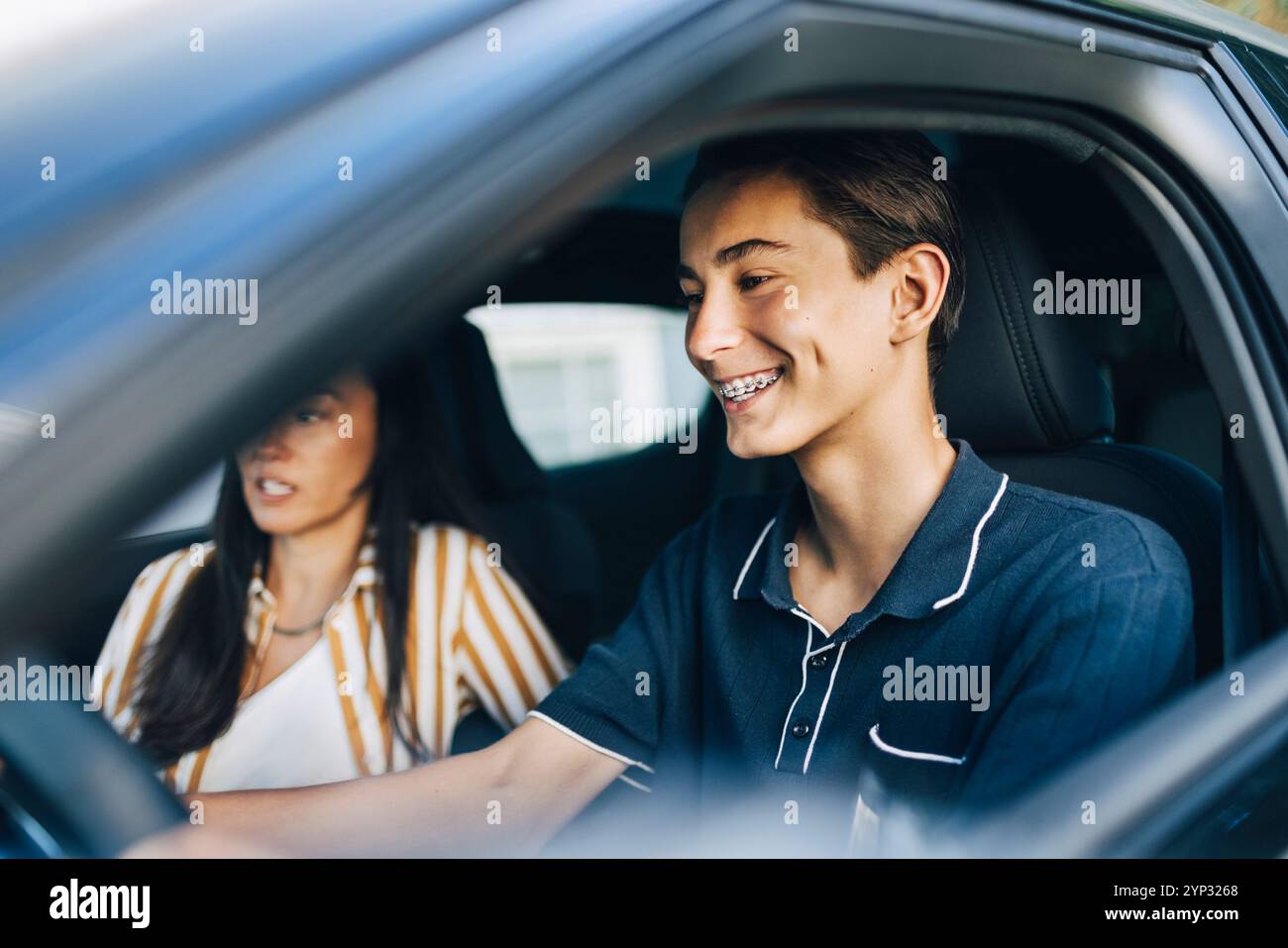 Happy teenage boy learning to drive car with mother Stock Photo - Alamy