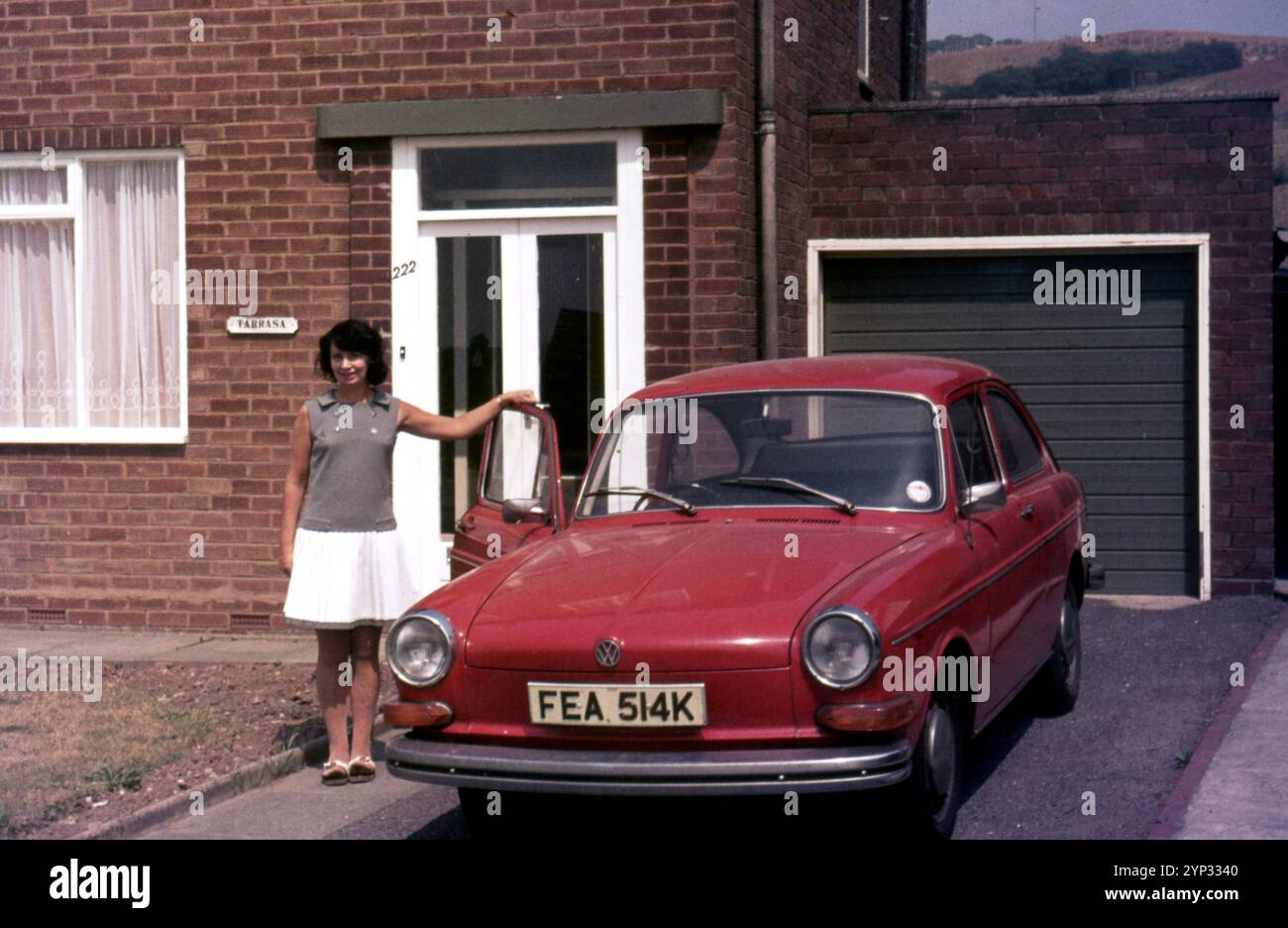 Woman by a red VW Car and house in the UK 5th July 1976. Photo by The ...