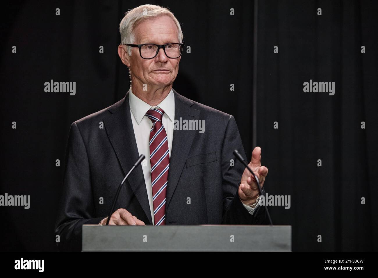 Medium shot of senior politician in formal attire giving public speech ...