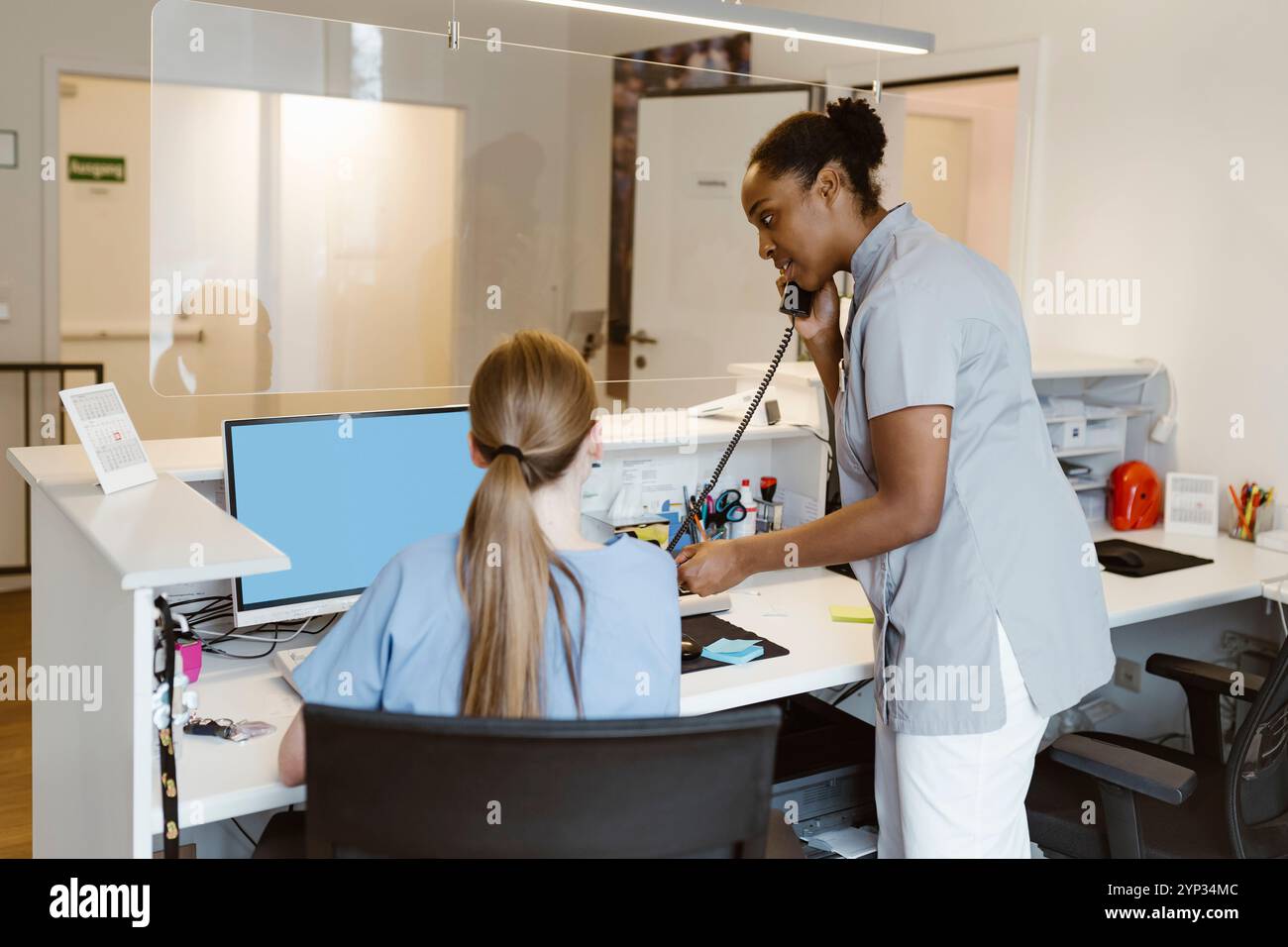 Side view of female healthcare professional attending call while ...