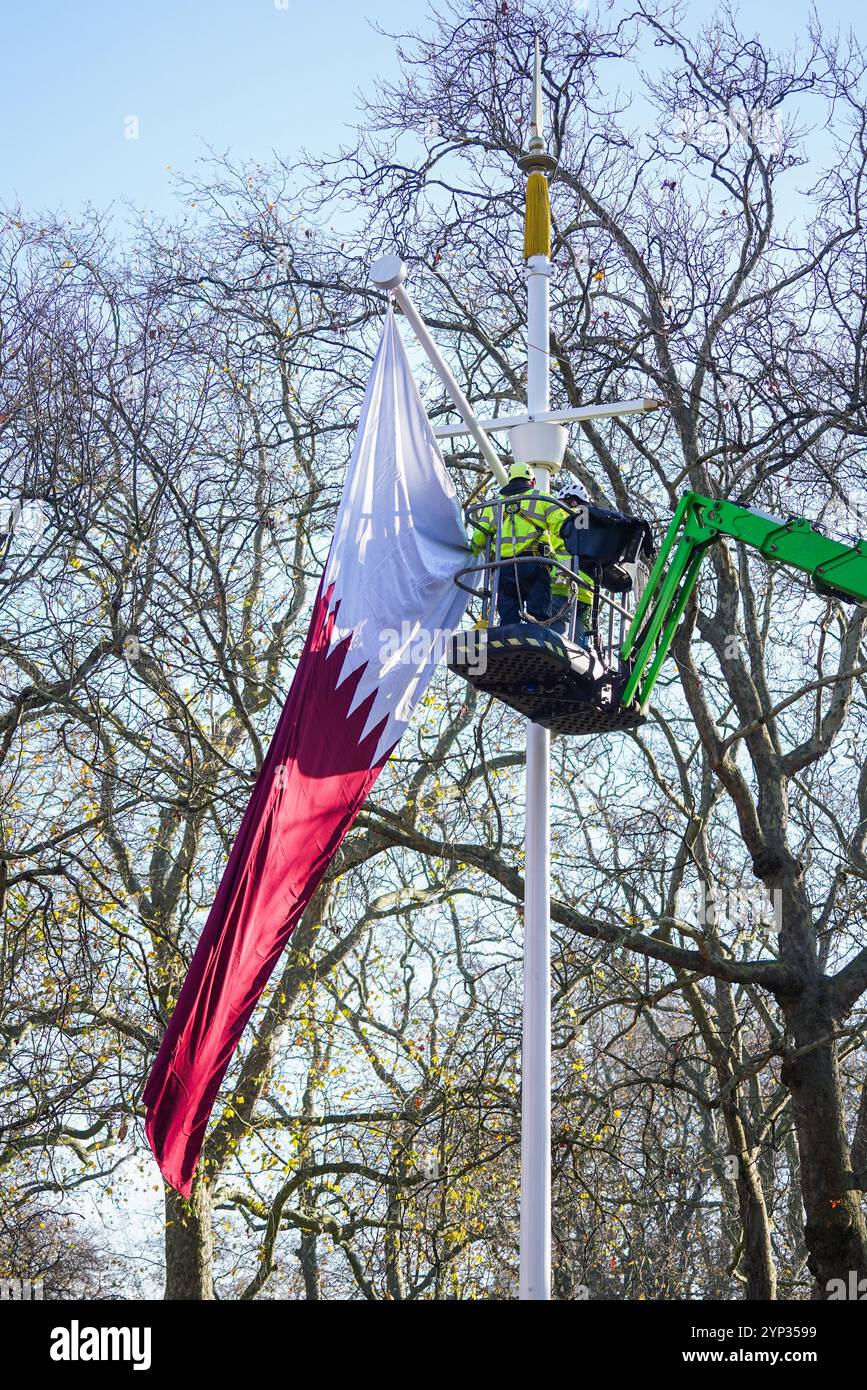 London, UK. 28 November 2024 Flag engineers on a cherry picker hang the ...