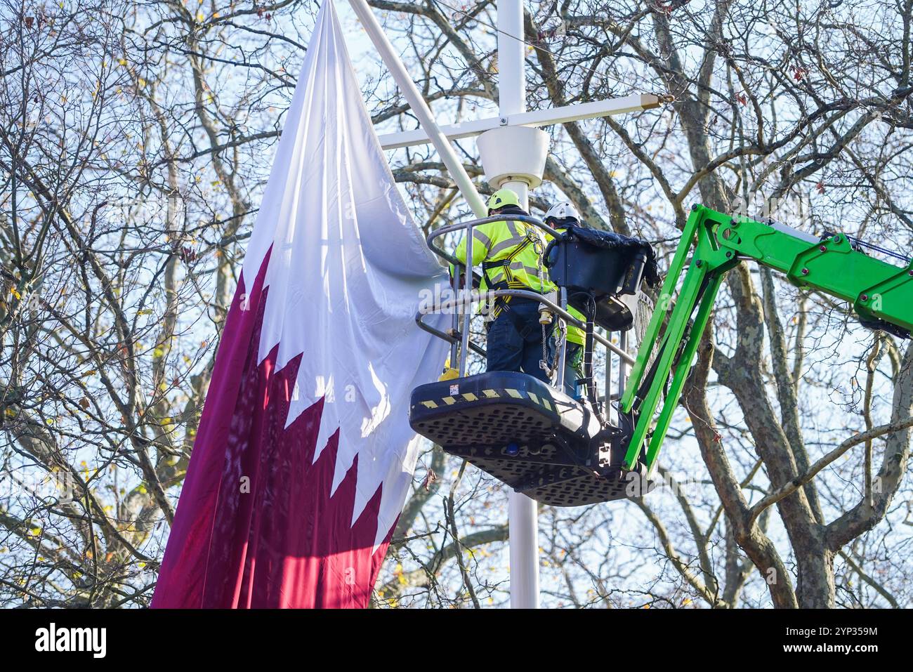 London, UK. 28 November 2024 Flag engineers on a cherry picker hang the ...