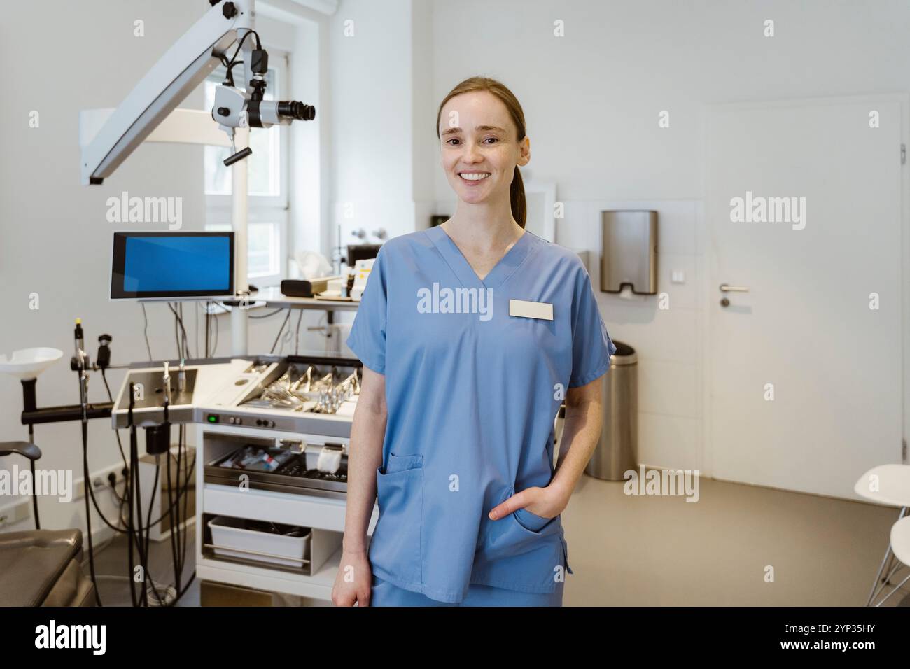 Portrait of confident female medical expert standing with hand in ...