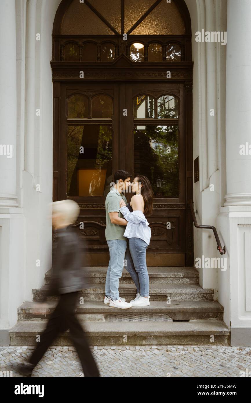 Side view of romantic couple standing on steps near door Stock Photo ...