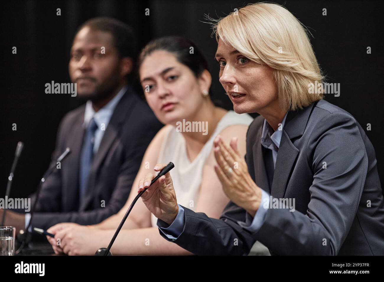 Expressive female official speaking into microphone participating in ...