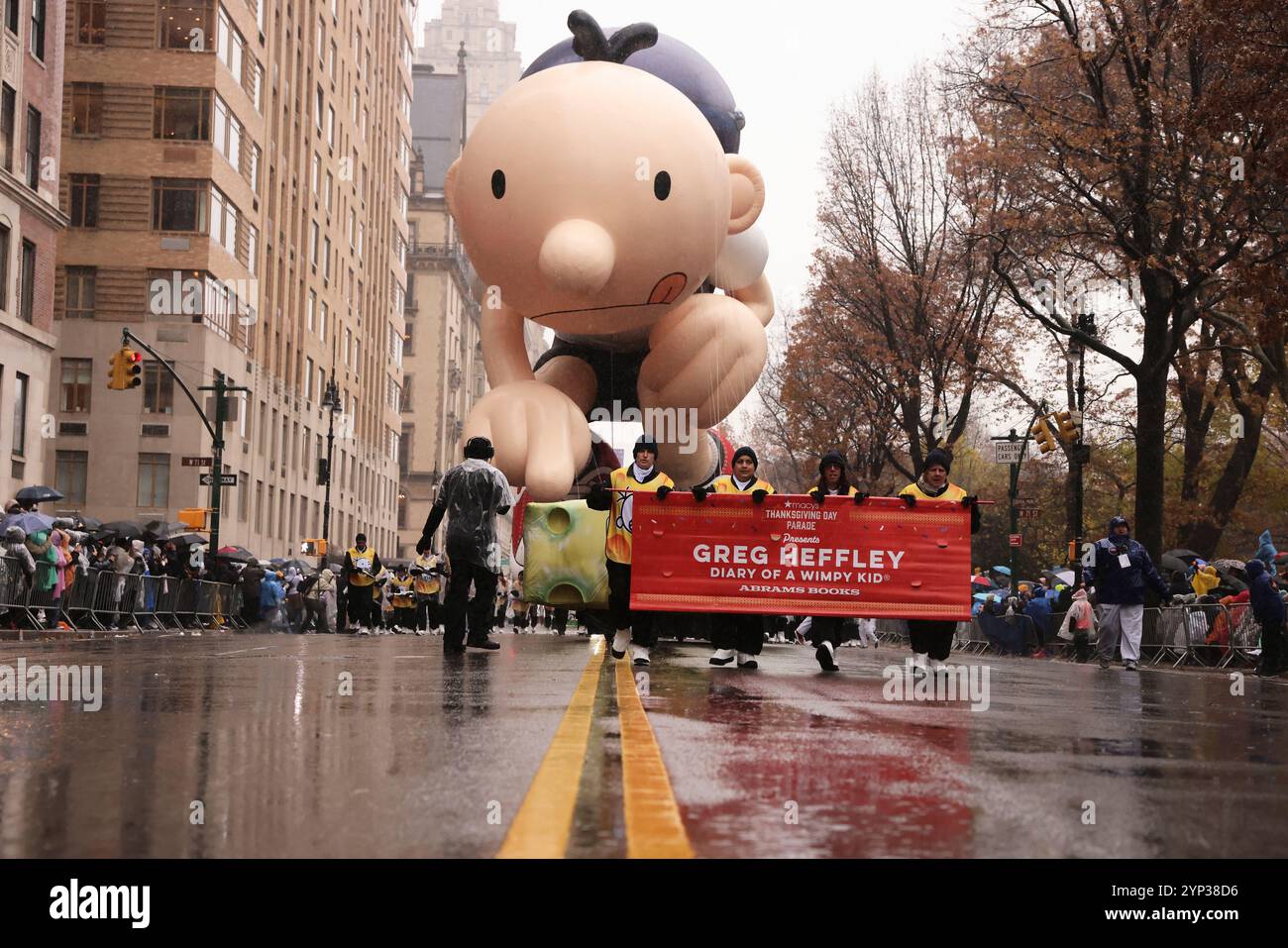 Handlers pull the Diary of a Wimpy Kid balloon down Central Park West ...