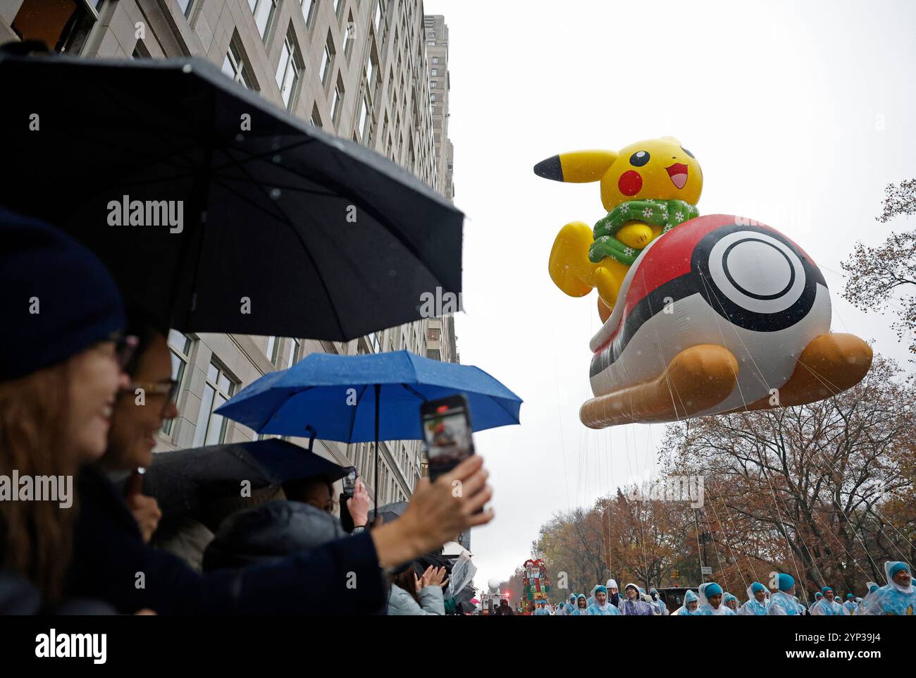 Spectators brave the rain to watch as the Pikachu and Eevee balloon ...