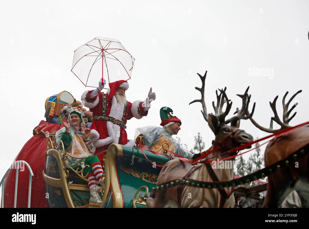 A float carrying Santa and his elves rides down Central Park West ...