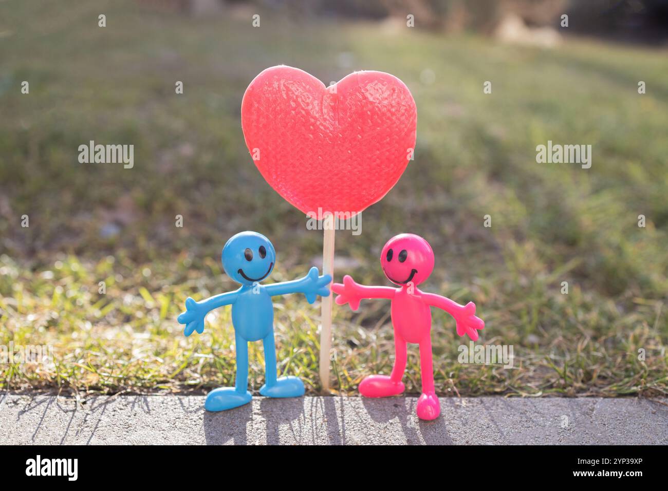 pink and blue miniature toy figures of people near heart-shaped ...