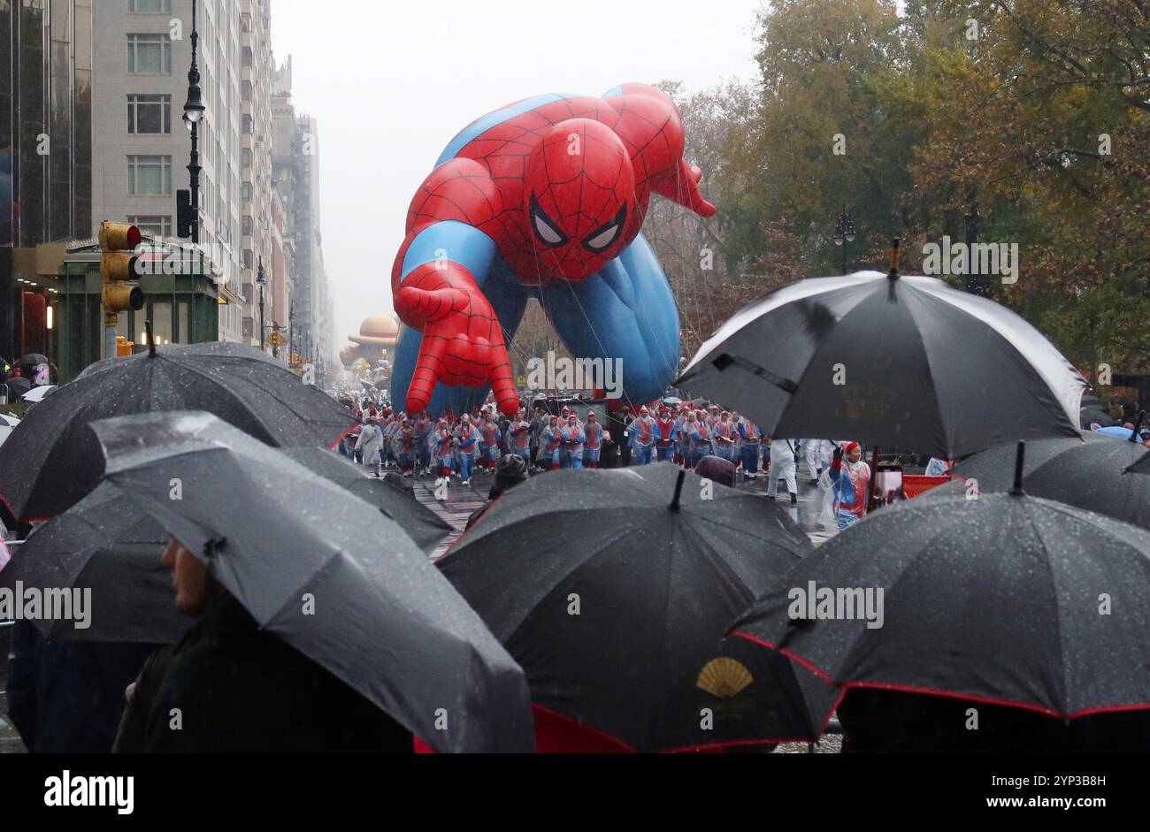 New York, United States. 27th Nov, 2024. Spectators huddle under ...