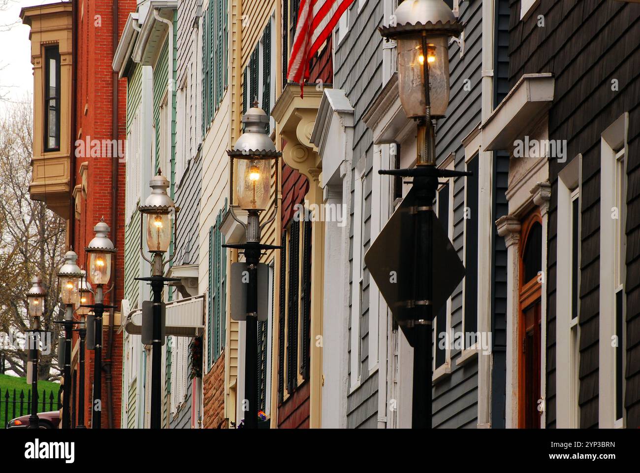 Streetlamps begin to glow amongst the Colonial Row houses in ...