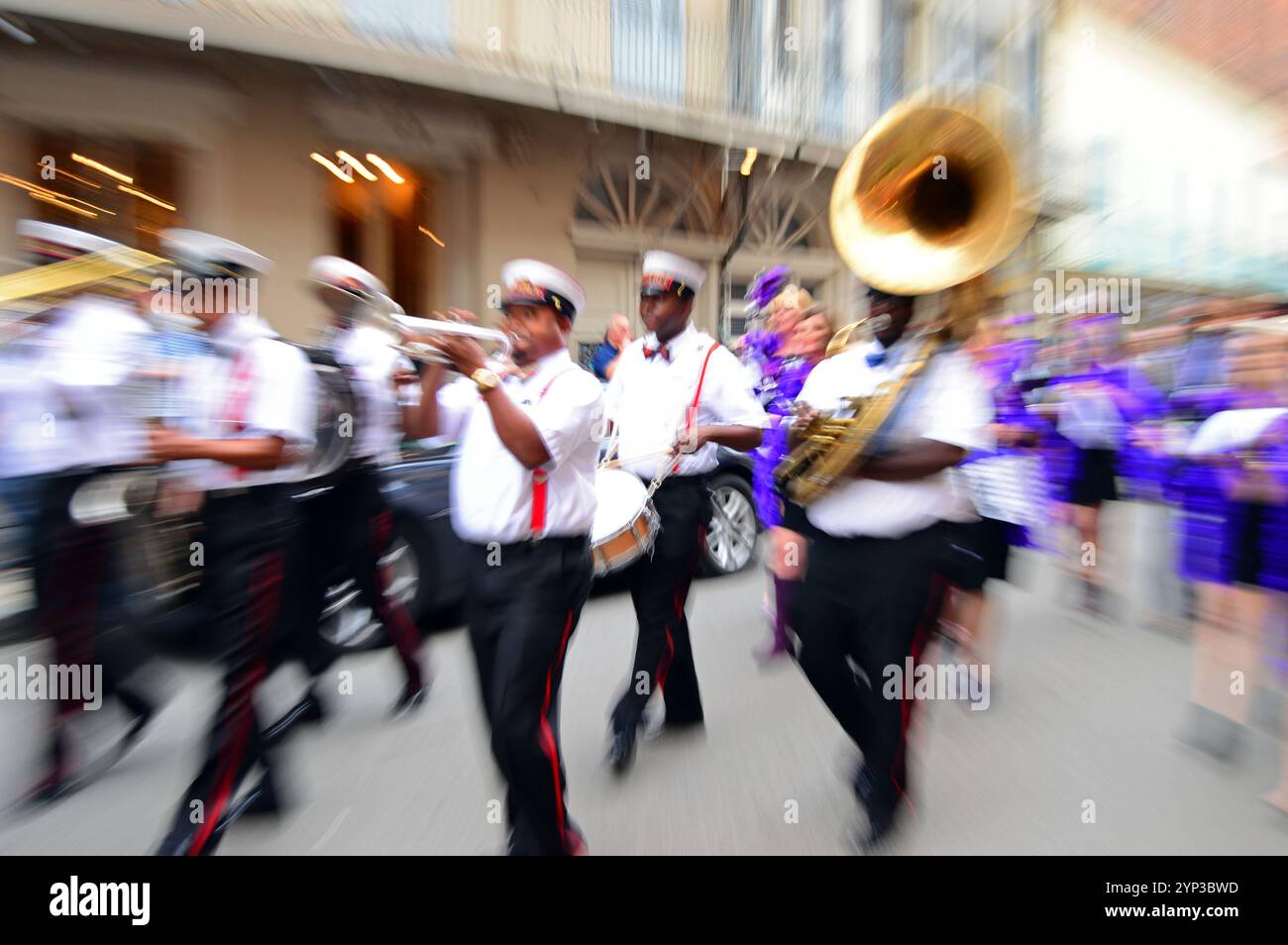 A zoom shot of a second line jazz band marching through the French ...