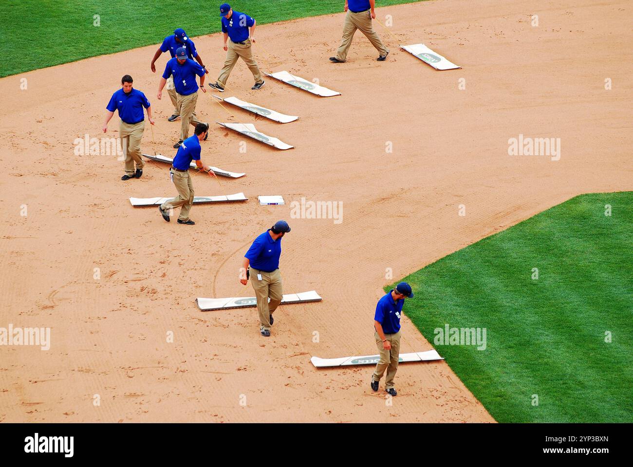 The grounds crew sweeps the infield dirt at a Chicago Cubs baseball ...