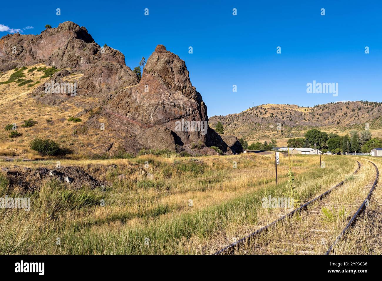 Railroad tracks run below the rocky cliffs near Craig in Montana, USA ...