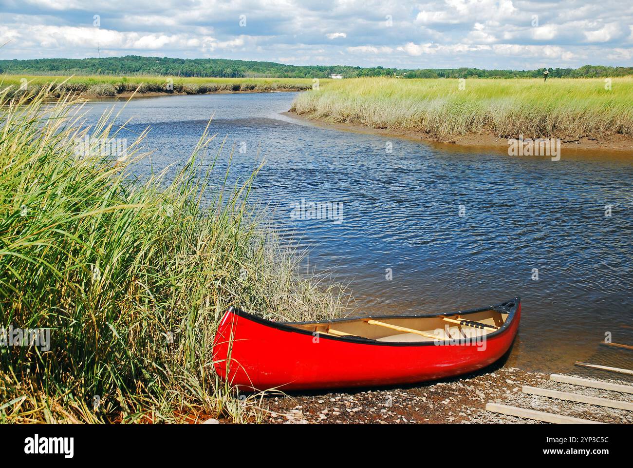 A canoe is ready for adventure on the shore of a marsh and wetland in ...