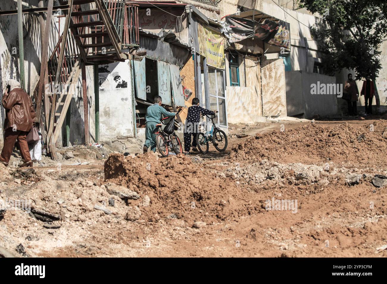 Tubas, Palestine. 28th Nov, 2024. Palestinians walk along a completely ...