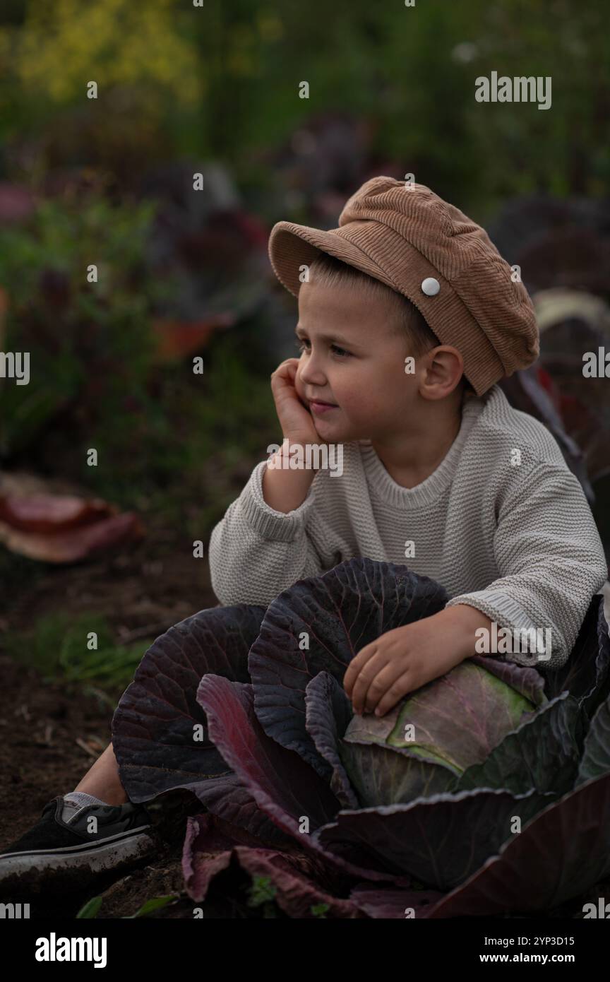 kid is sitting in a cabbage with hat Stock Photo - Alamy