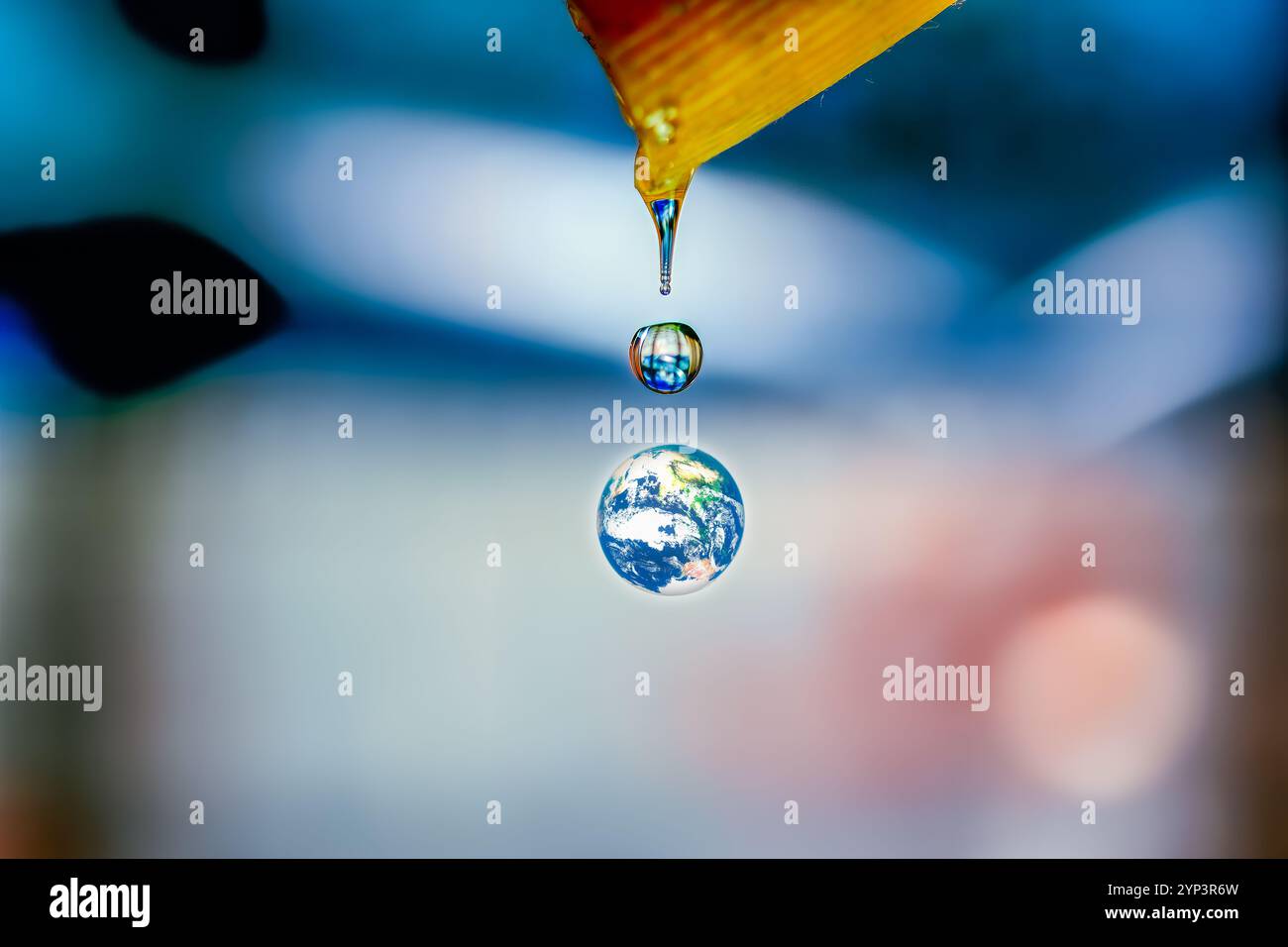 A droplet of water falling from a pipe with a reflection of Earth. This ...