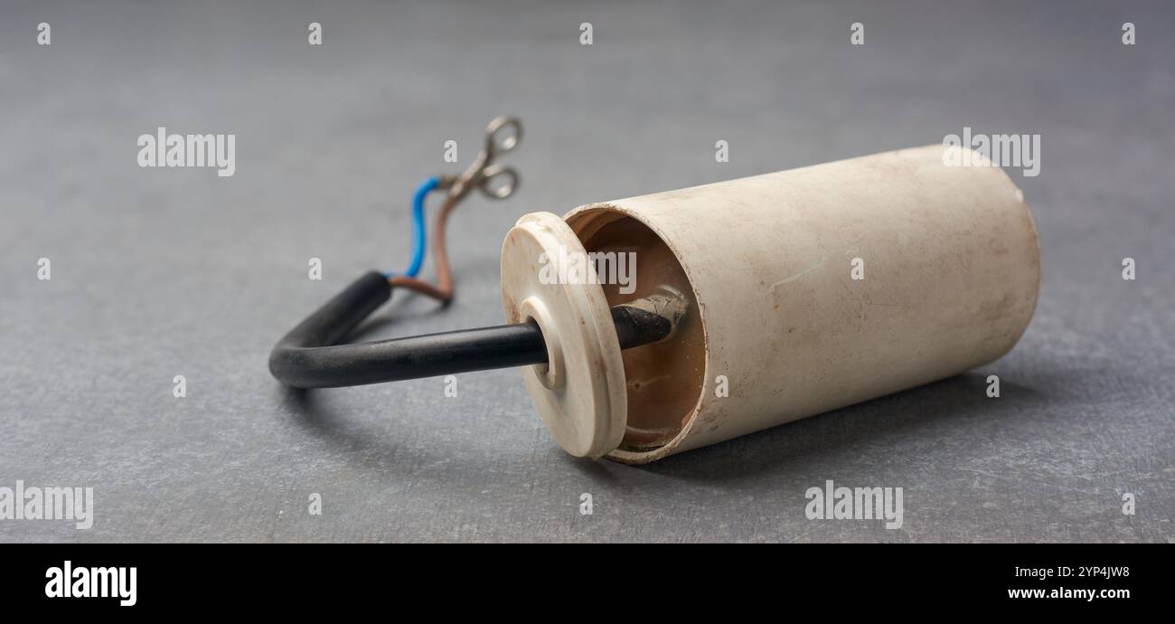 old cylindrical capacitor with metal terminals isolated on textured ...