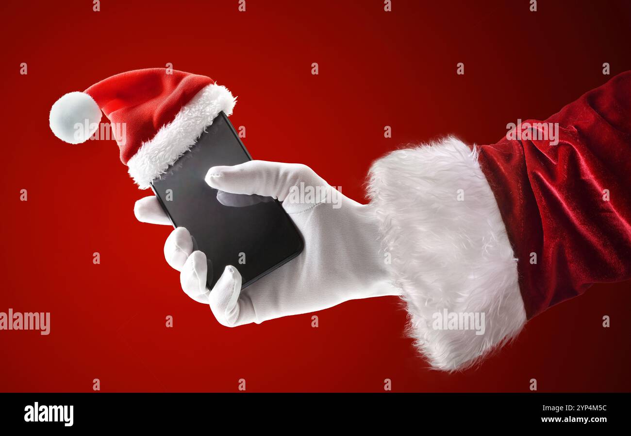 Santa Claus hand in suit and gloves holding a smart phone with a Santa ...