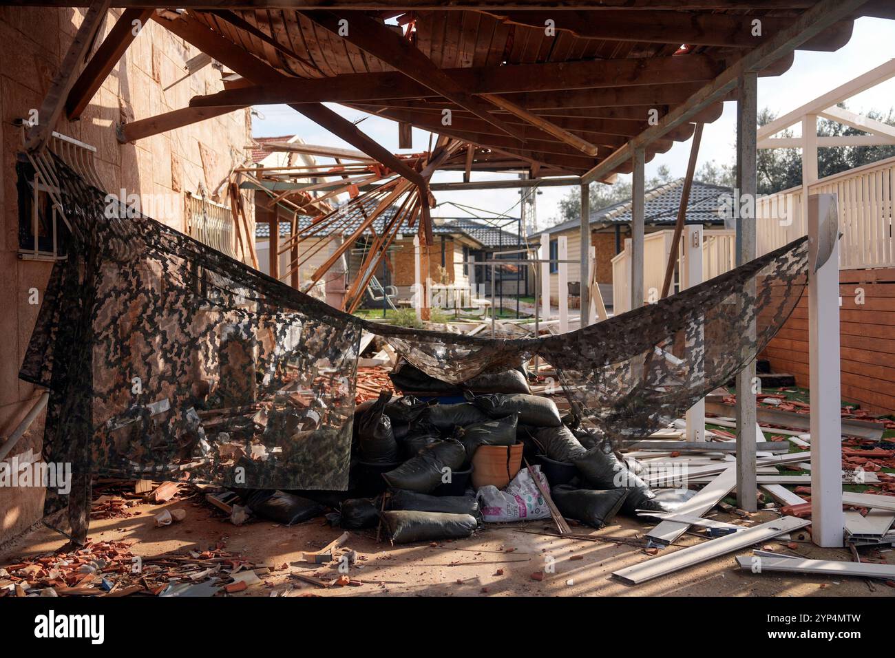 Plastic bags sit under a damaged roof in the agricultural settlement of ...