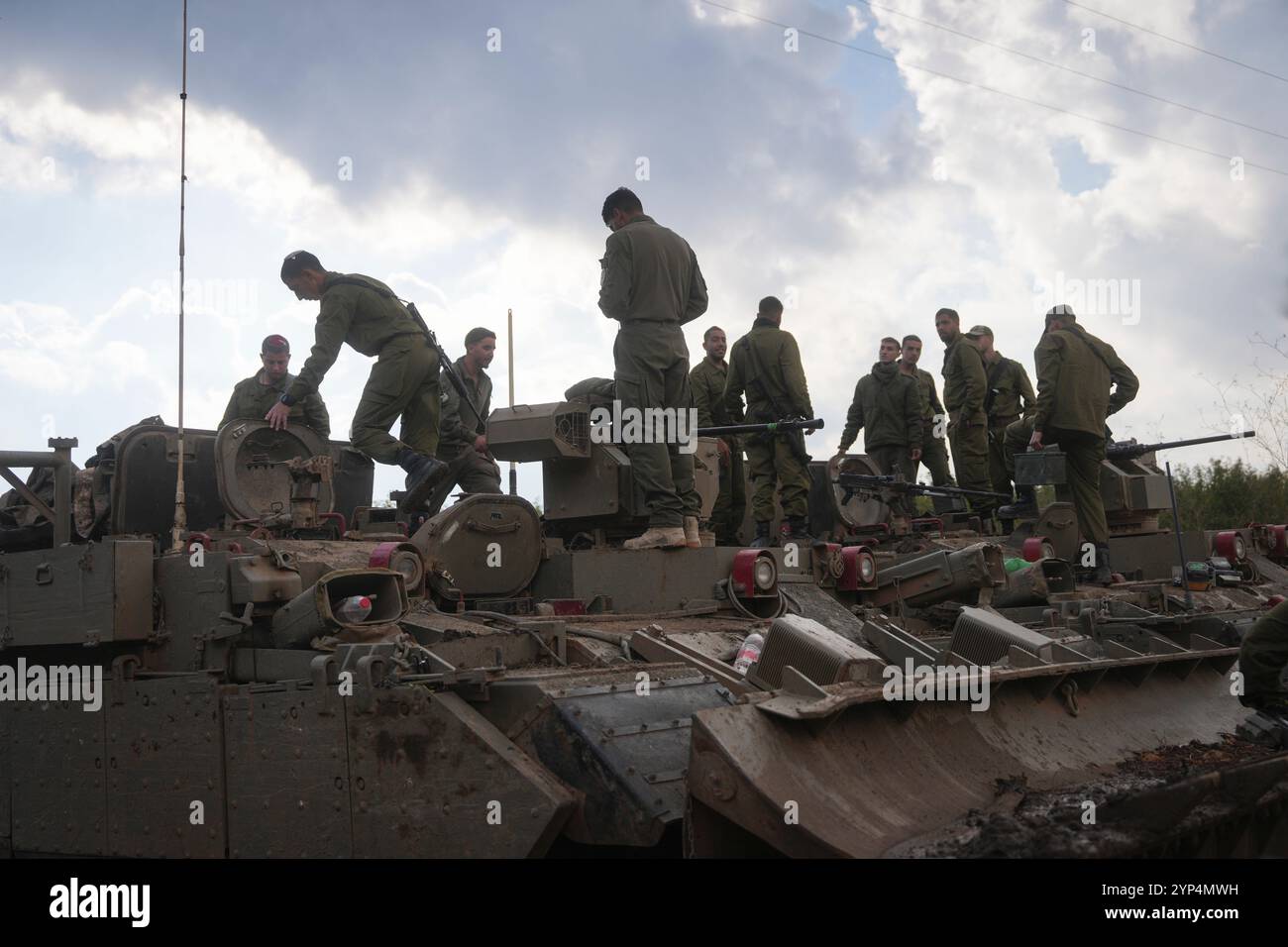 Israeli soldiers stand atop army armoured vehicles outside the ...