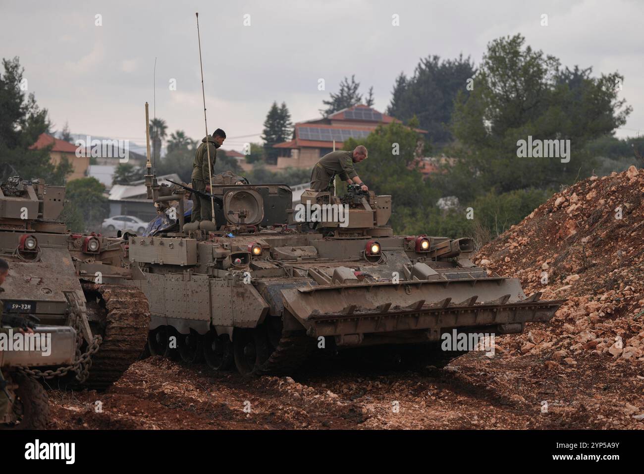 Israeli soldiers stand atop army armoured vehicles outside the ...