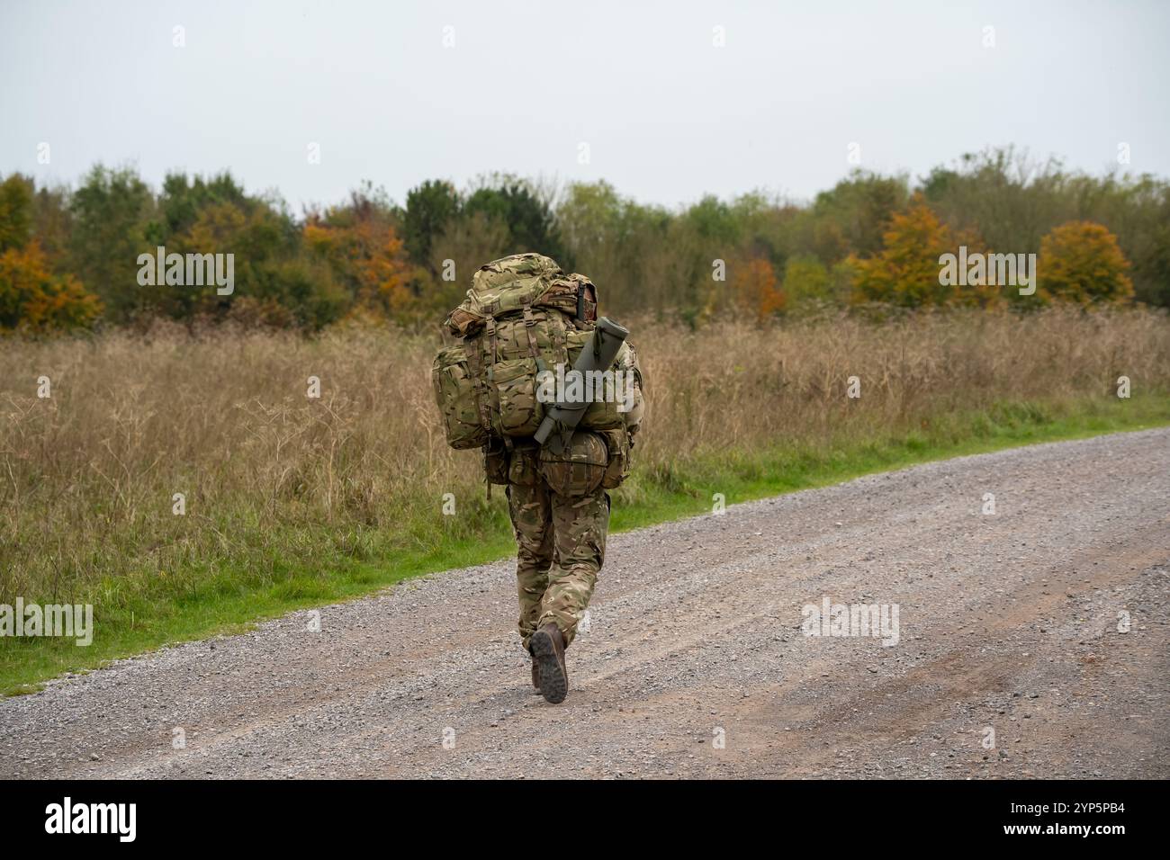 a unit of British army soldiers tabbing with 40Kg bergen along a dirt ...