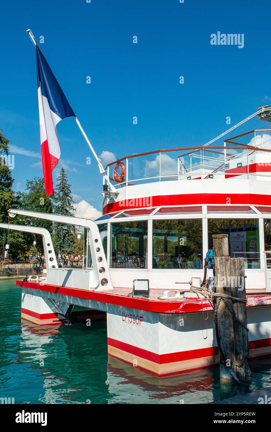 French flag flying off the back of a pleasure boat docked in Annecy, a ...