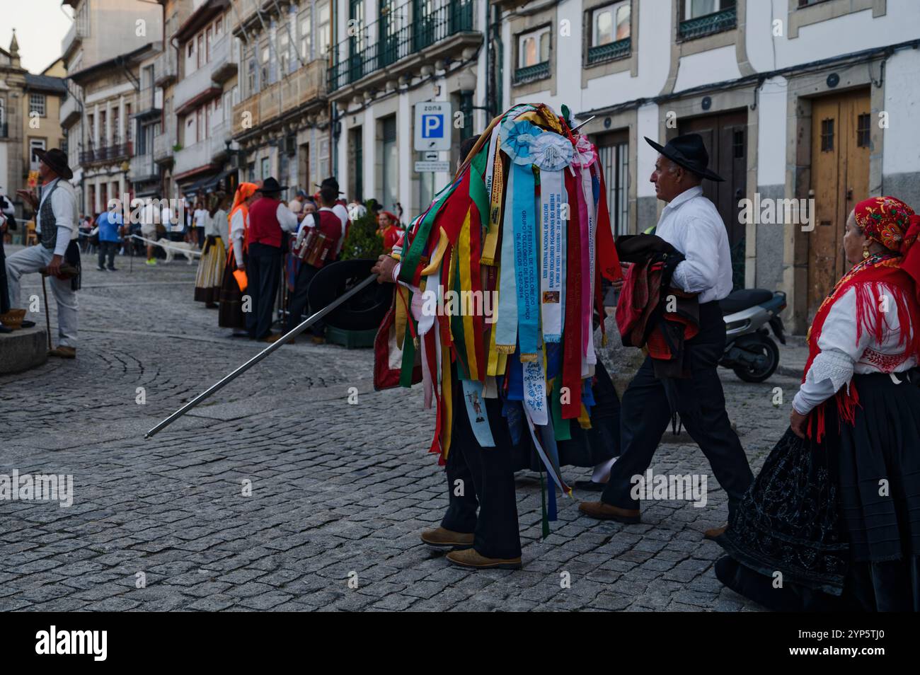 Traditional parade with colorful ribbons and folk attire during ...