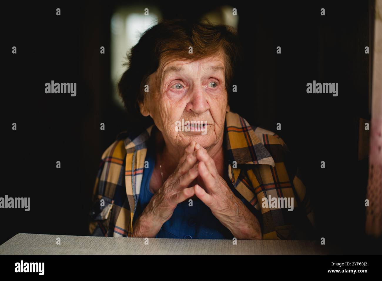 A touching portrait of an emotional elderly woman in her home, her face ...