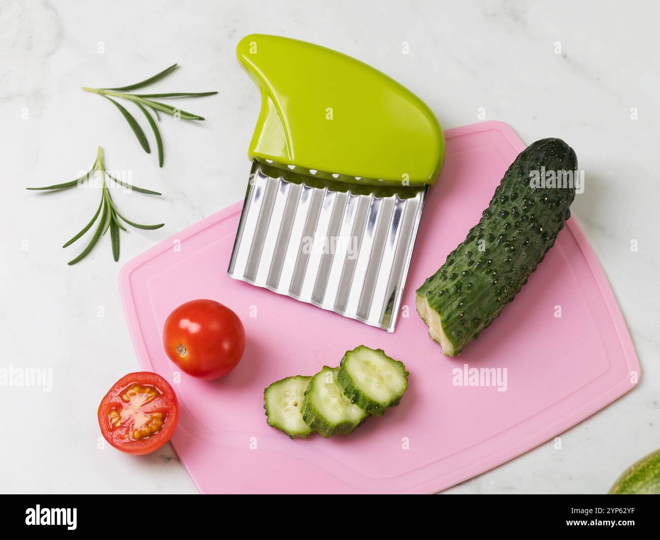 A stainless steel vegetable cutter and chopped vegetables on a table ...
