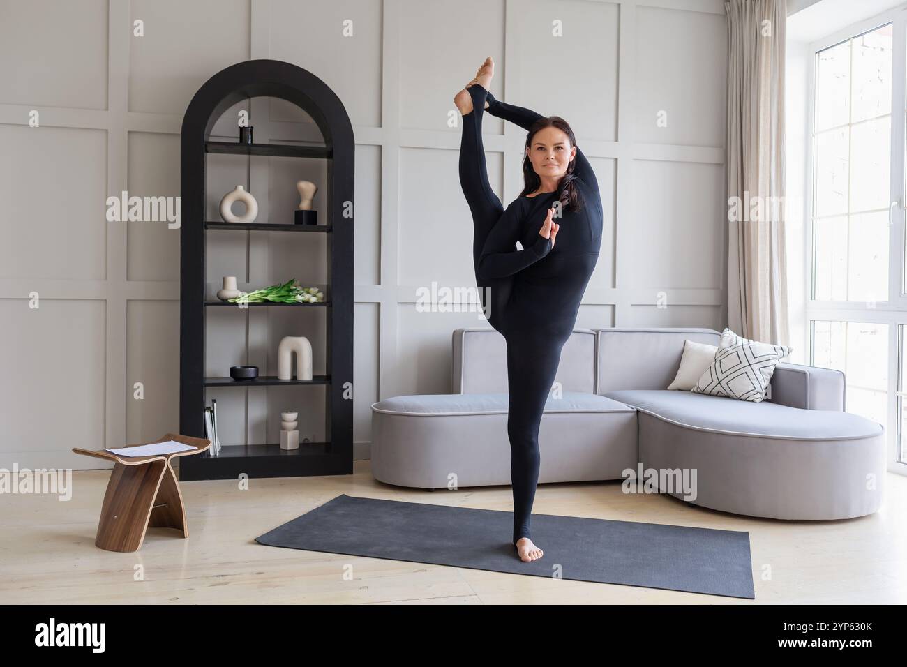 Woman practicing hatha yoga, doing variation of utthita hasta ...