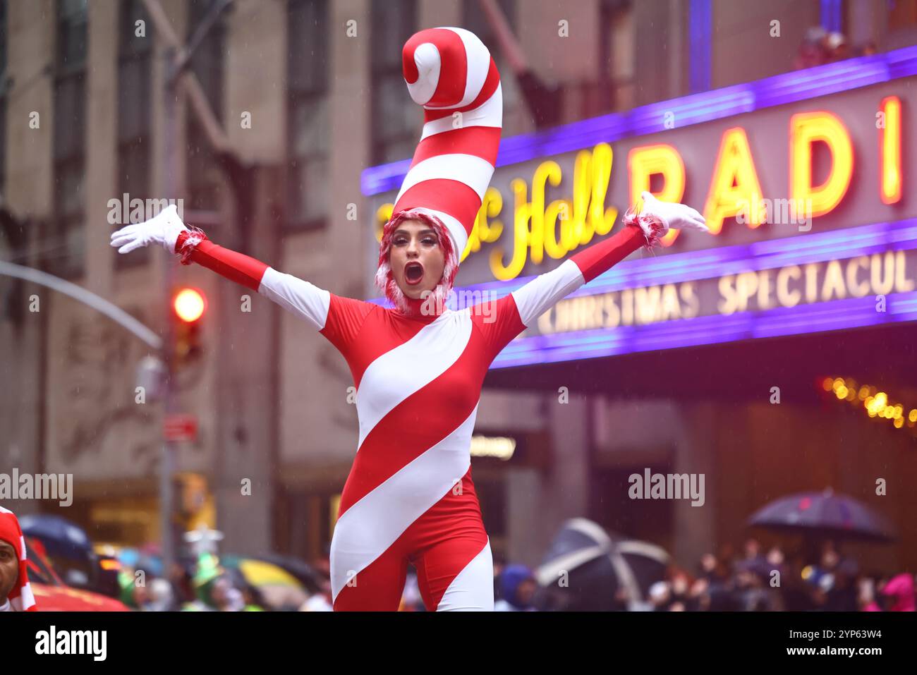 A performer dressed as a candy cane head down Sixth Avenue during The ...