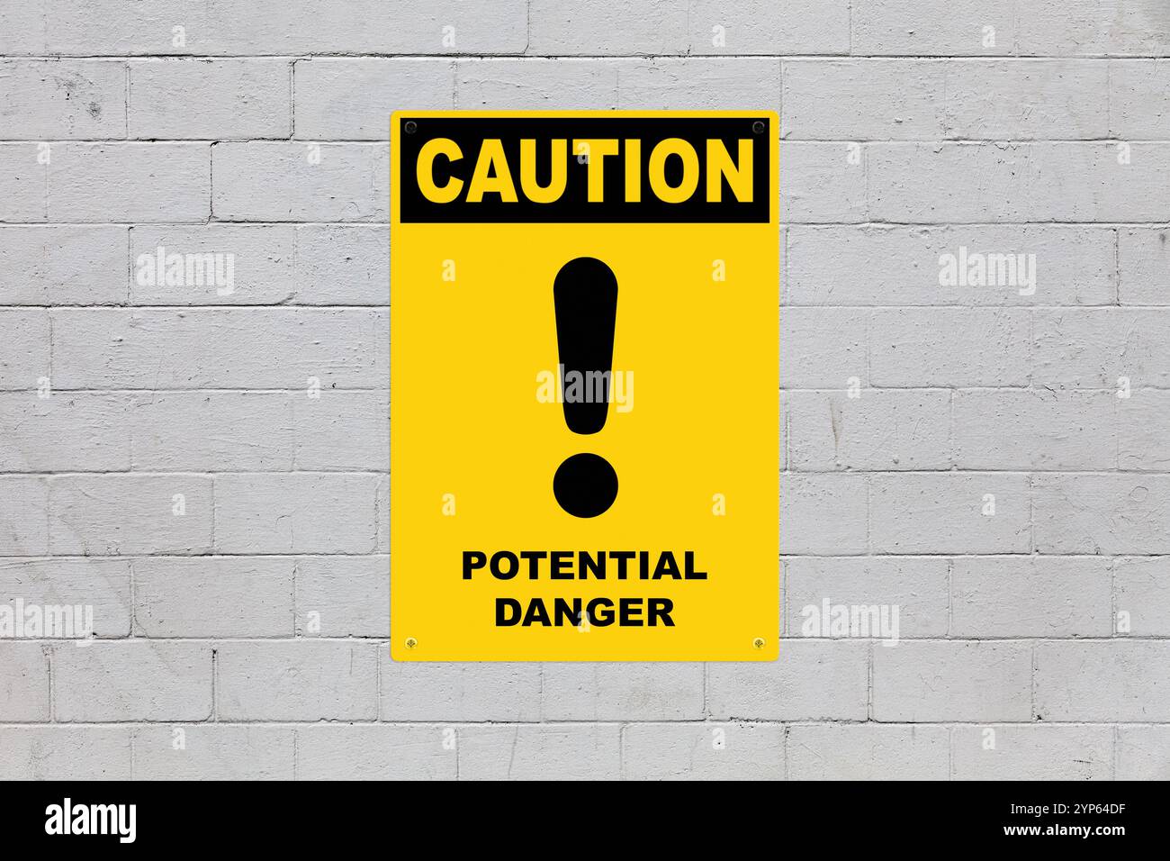 Yellow warning sign screwed to a cinder block wall to warn about a ...