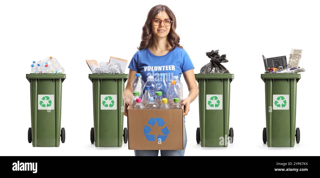 Young female volunteer carrying a cardboard box with plastic bottles in ...