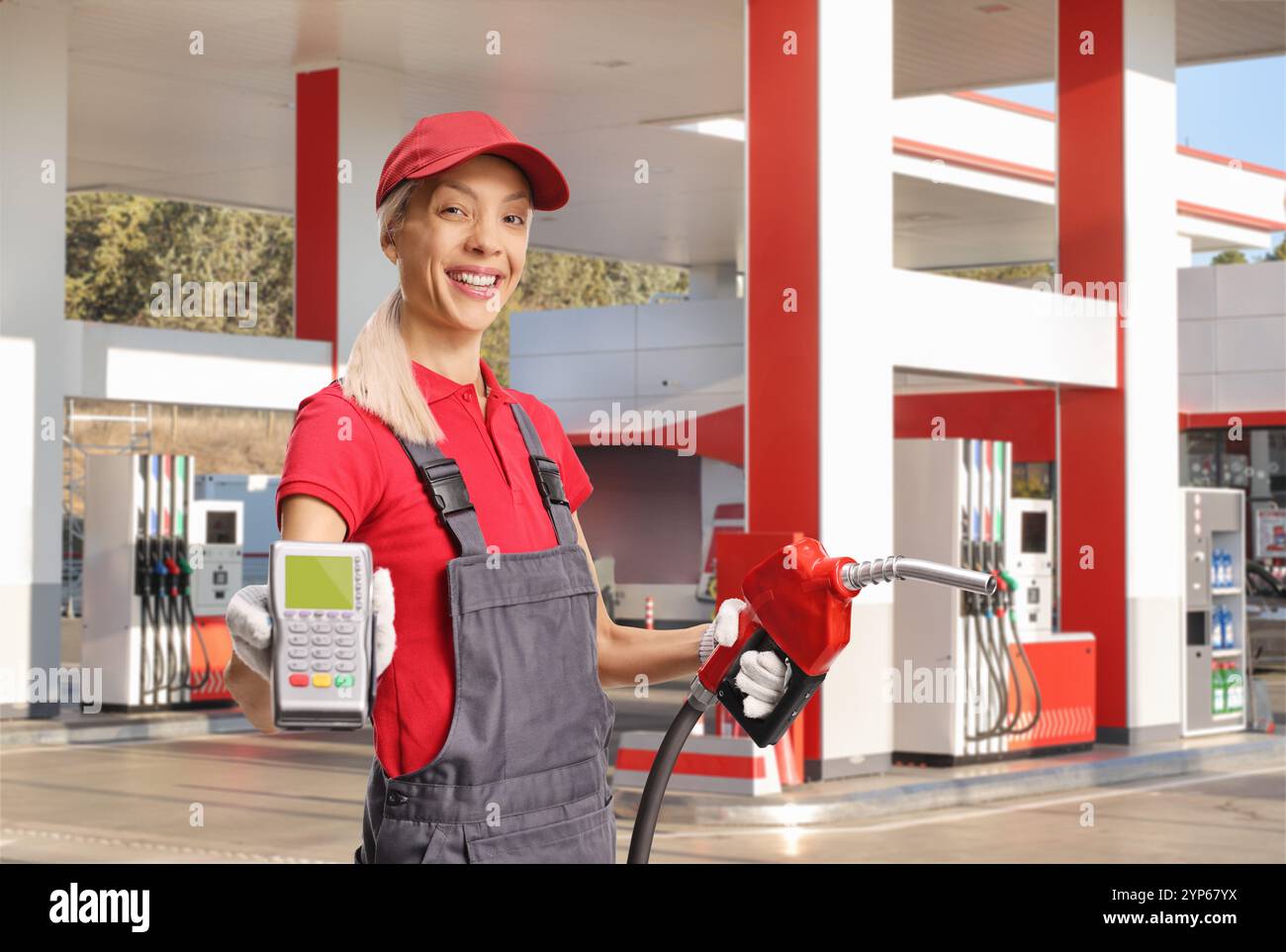 Female gas station worker holding a refuel gun and a credit card terminal Stock Photo - Alamy
