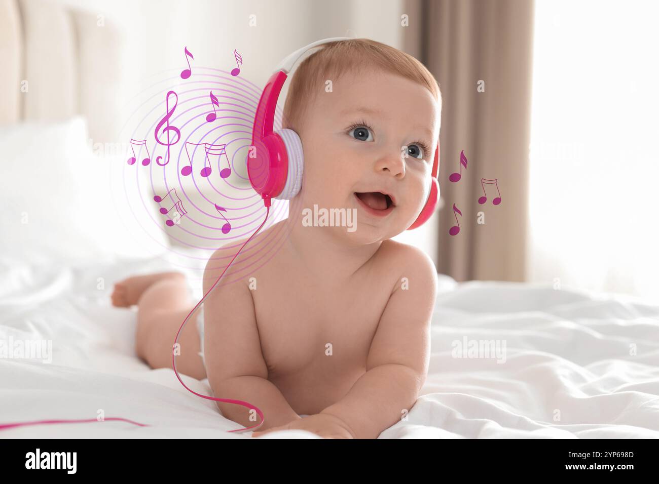 Cute little baby with headphones on bed at home. Music notes flying ...