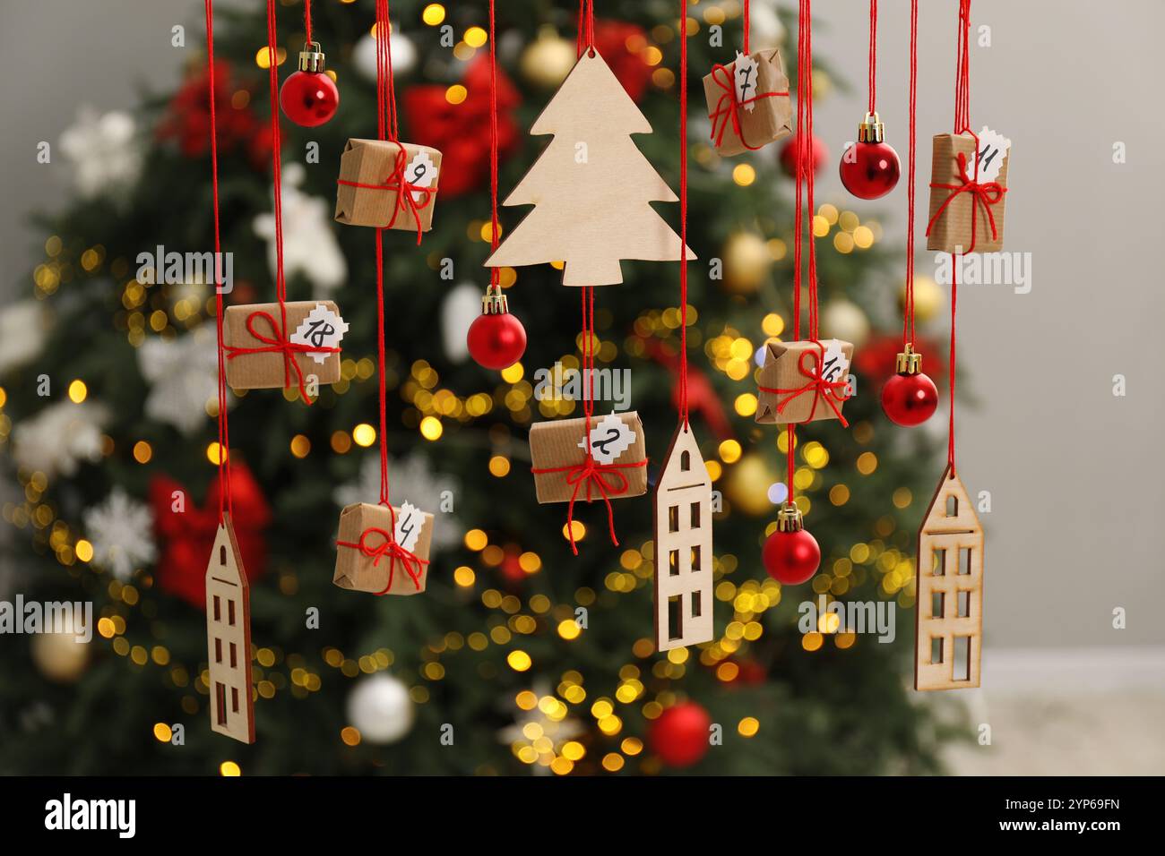 Handmade advent calendar with decor hanging near Christmas tree indoors ...