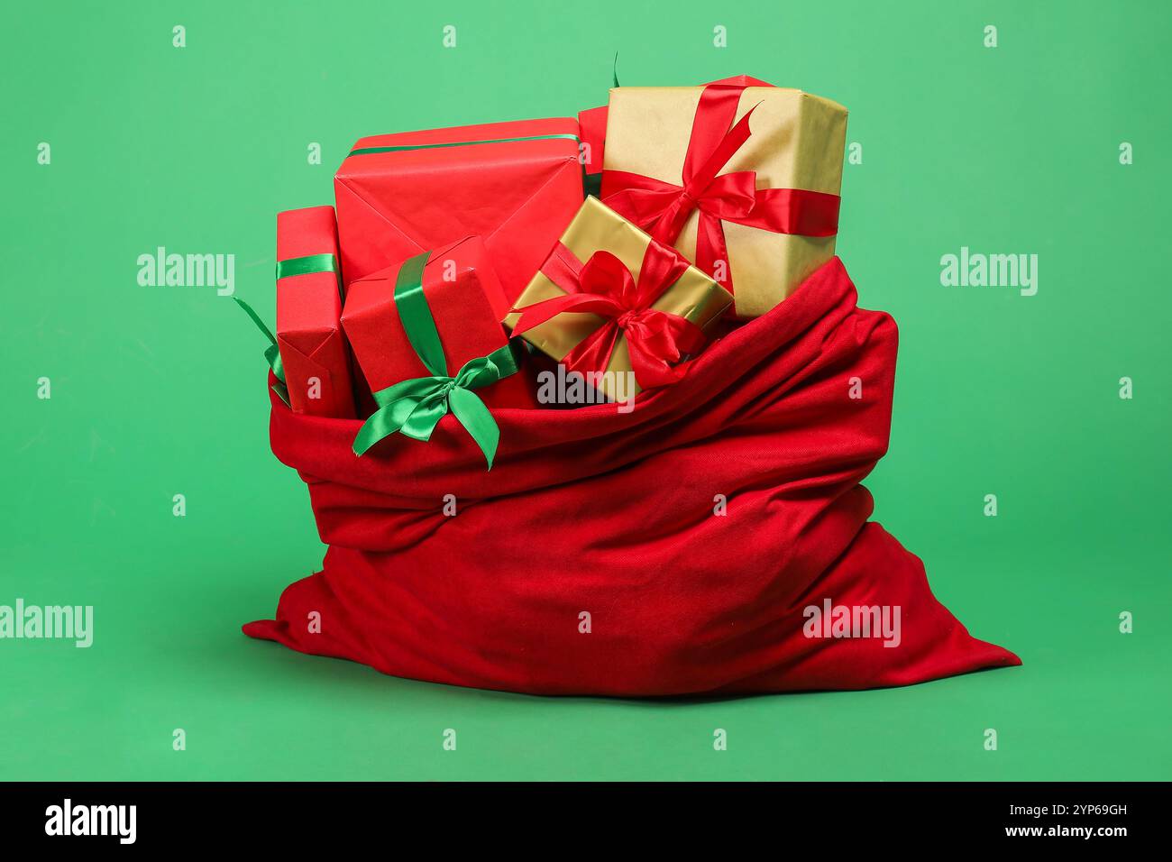 Red Santa Claus bag with gift boxes on green background Stock Photo - Alamy