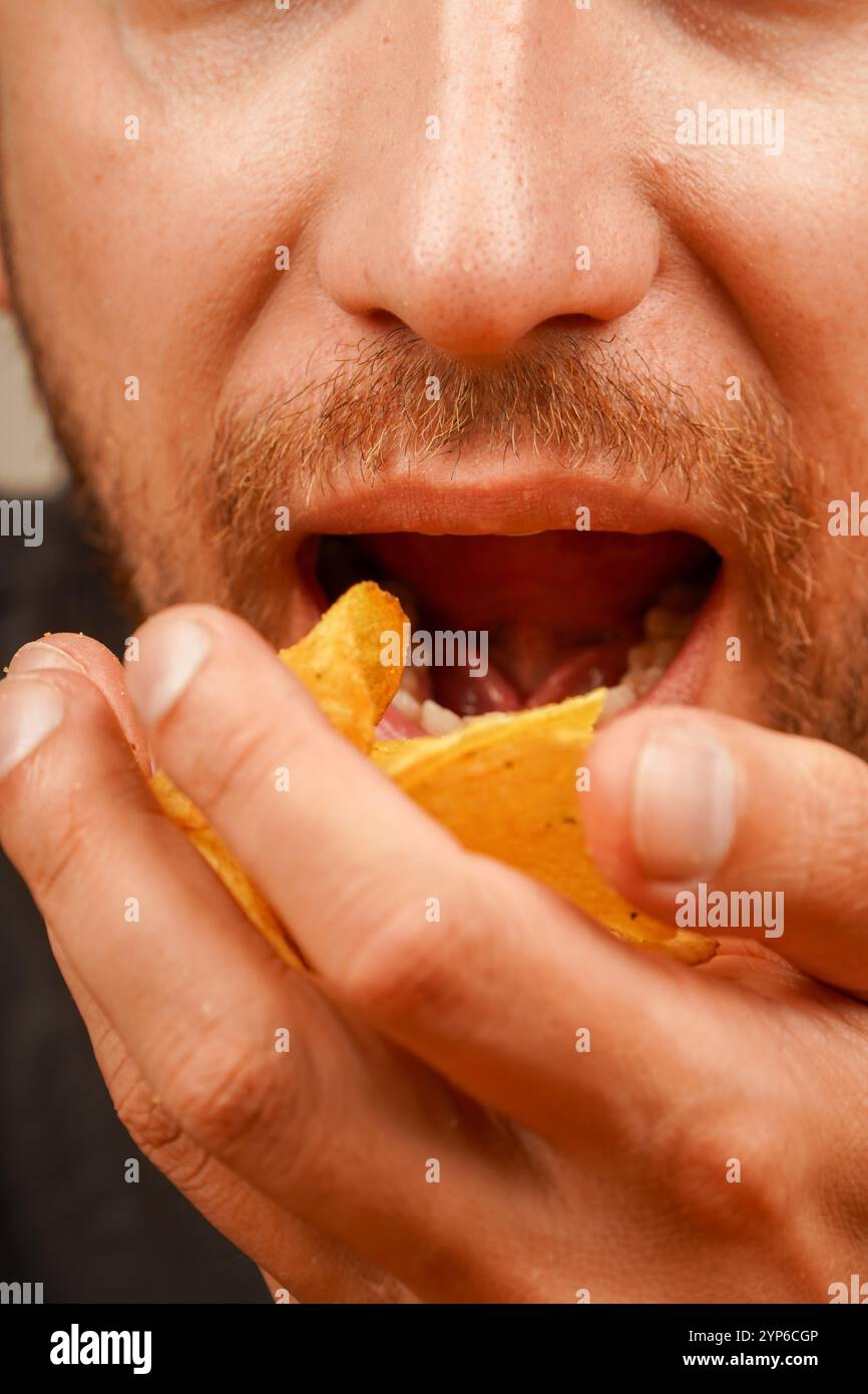 Fat man eating chips hi-res stock photography and images - Alamy