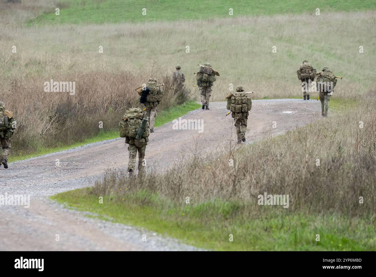 a unit of British army soldiers tabbing with 40Kg bergen along a dirt ...