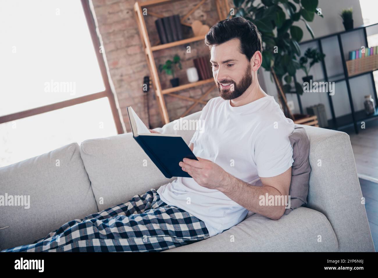 Photo of handsome clever man wearing nightwear weekend relax rest read ...