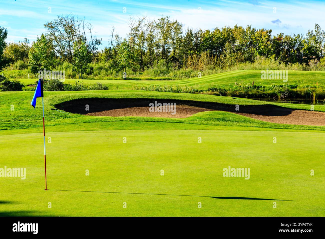 A blue flag is on a golf course. The flag is on a tee Stock Photo - Alamy