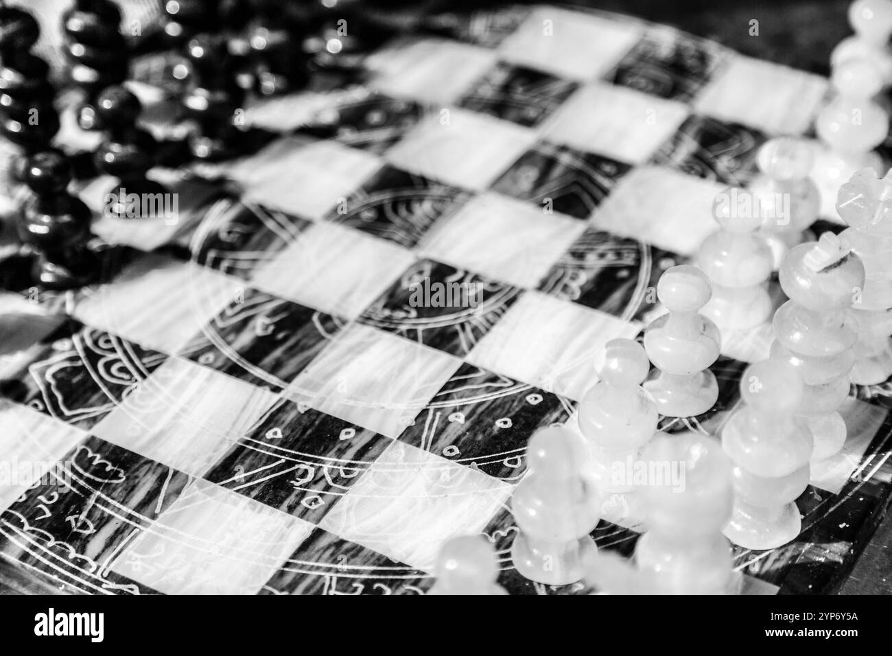 A black and white chess board with a white and black checker piece ...