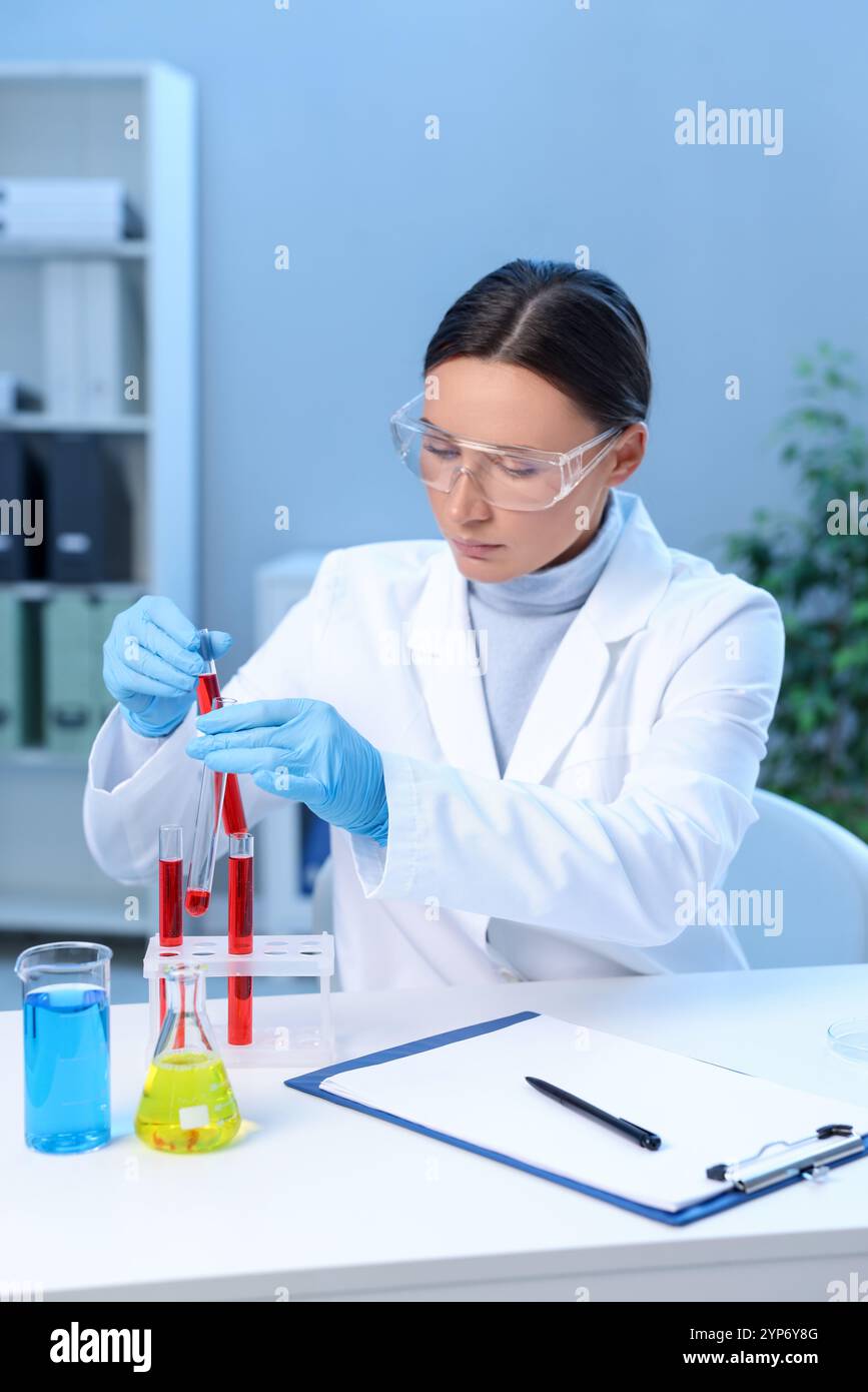 Laboratory testing. Doctor taking test tube with blood sample at table ...