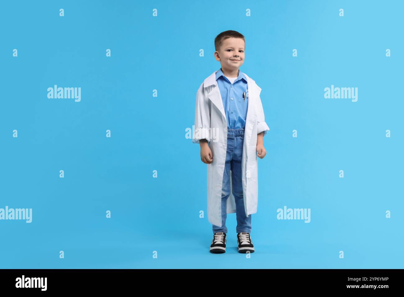 Little boy pretending to be doctor on light blue background. Dreaming ...