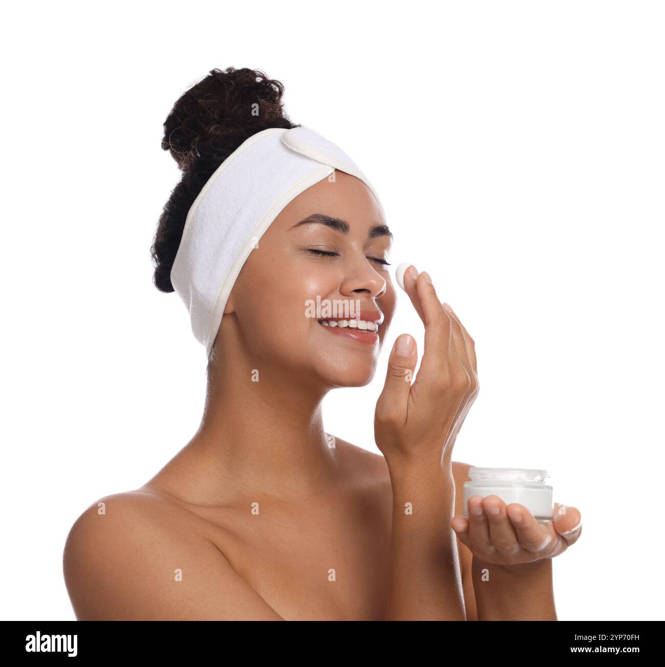Beautiful woman applying cream onto face against white background Stock ...