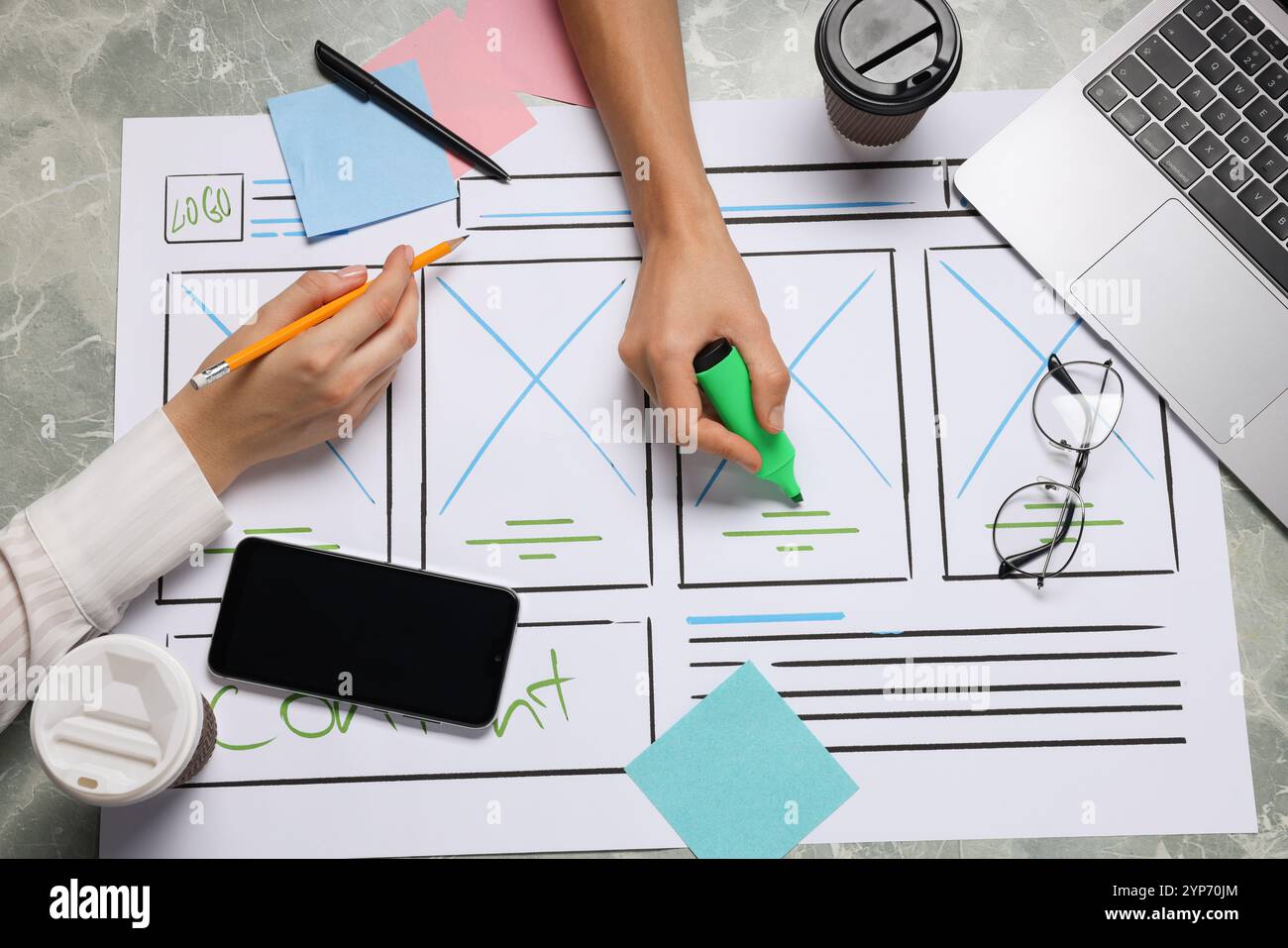 Developing UI design. Designers creating website wireframe on paper at ...